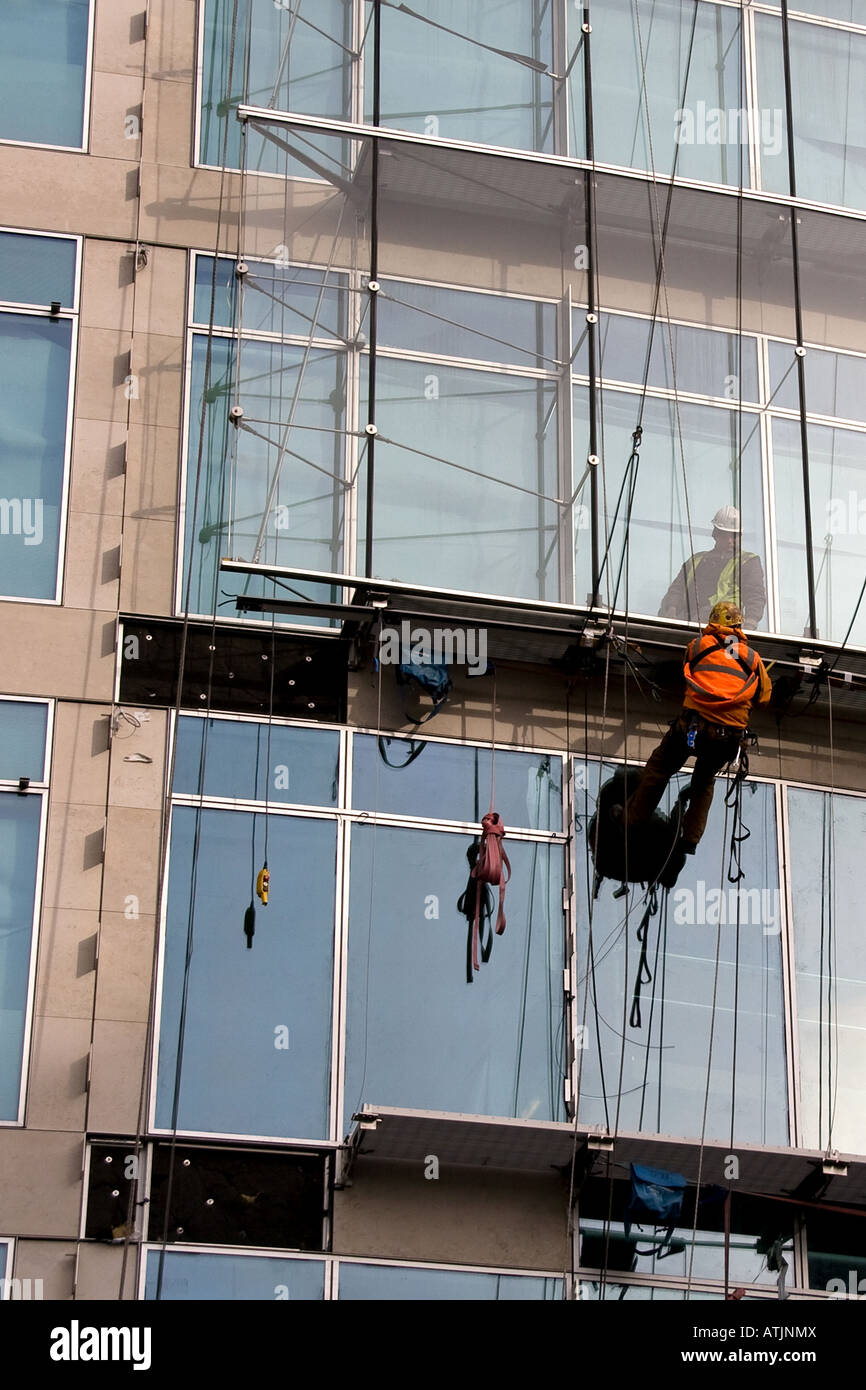 workmen working on side of large building, london uk Stock Photo - Alamy