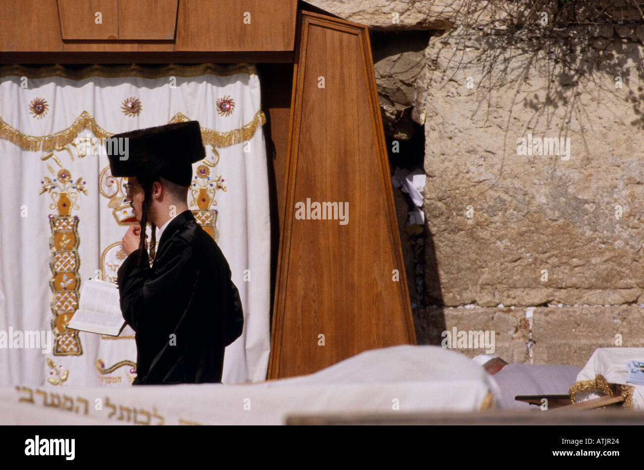 A man walking on a street beside the wailing wall Western Wall The ...