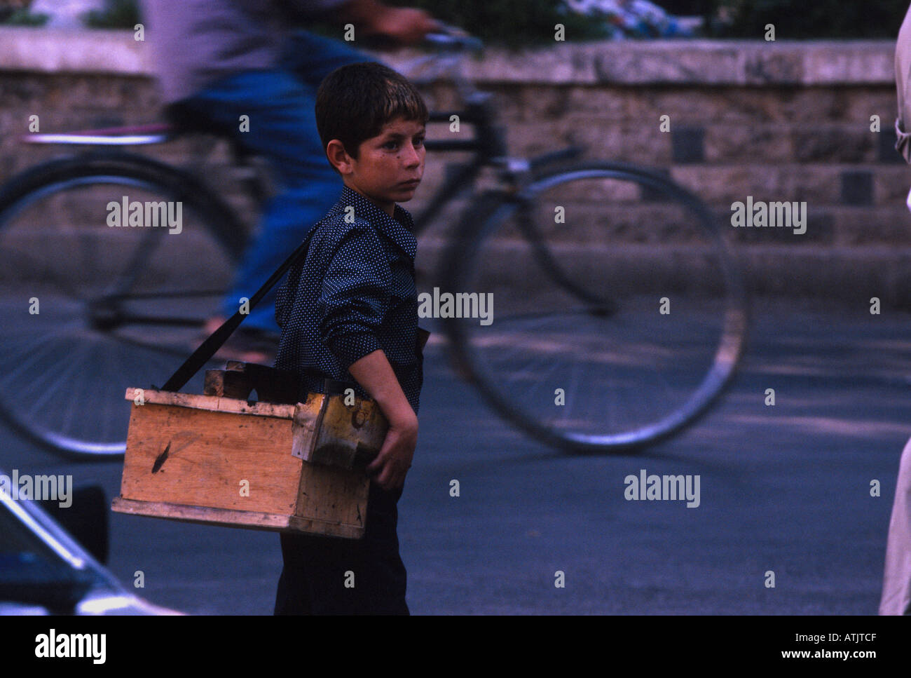 A boy carrying a chest walks on a street Stock Photo - Alamy