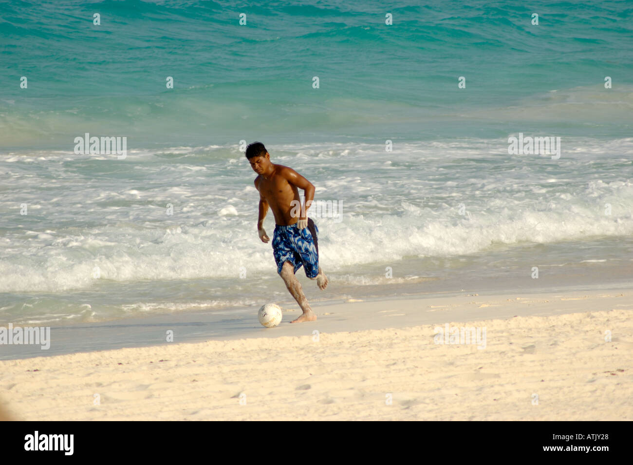 Young latin soccer player playing on the beach Cancun Mexico Quintana ...