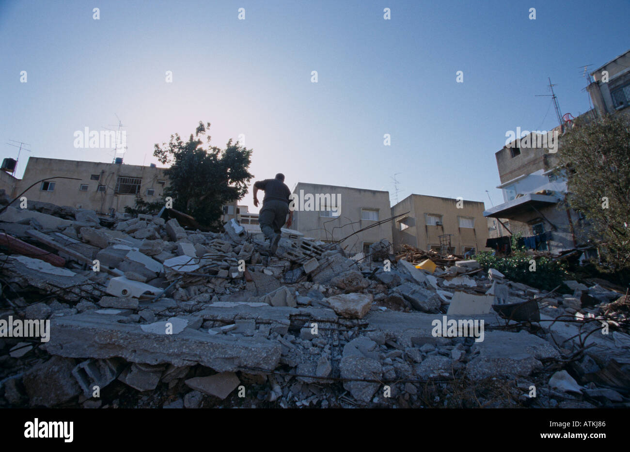 Man climbing up rubble of ruins of houses. Tulkarm Refugee Camp ...