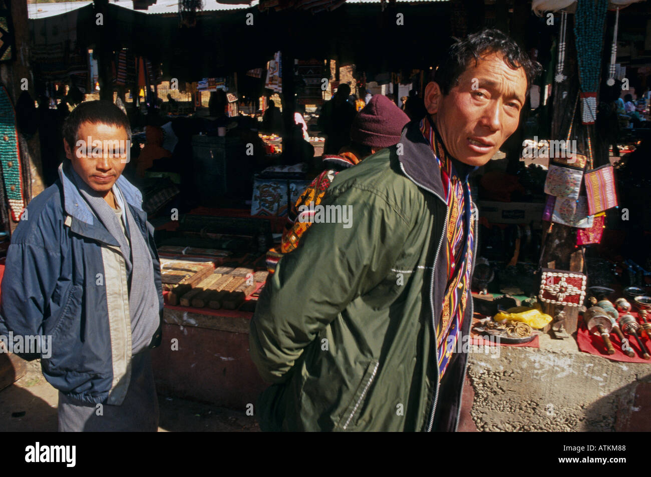 Men walk pass a stall in Bhutan Stock Photo - Alamy