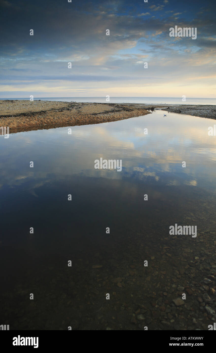 Pebble beach with stream running through it to the sea on the south ...
