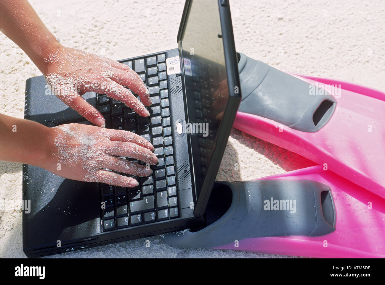 Sandy hands using laptop on beach during working holiday Stock Photo ...