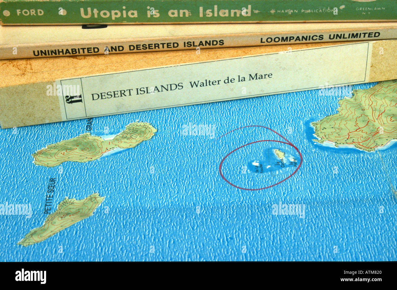 Books about desert islands resting on a map Stock Photo - Alamy
