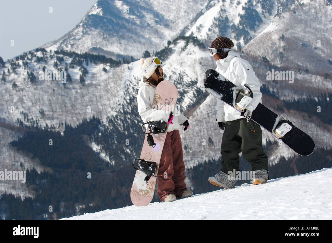 Two young Asian snowboarders with mountain backdrop Stock Photo - Alamy