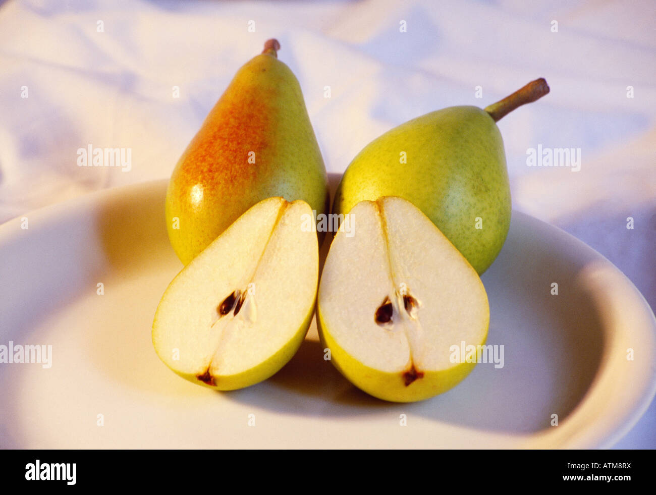 Still life with three pears in dish Stock Photo - Alamy