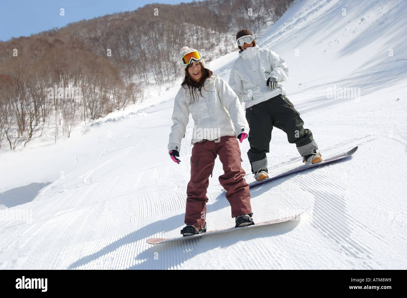 Two young Asian snowboarders looking at camera Stock Photo - Alamy