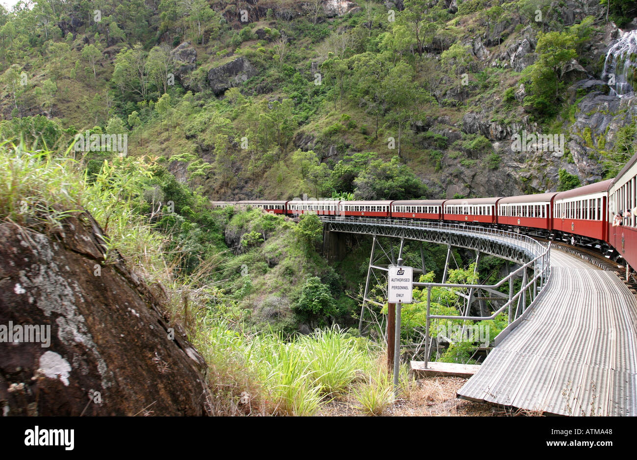 The Kuranda Scenic Steam Railway rounds a corner and crosses a bridge ...