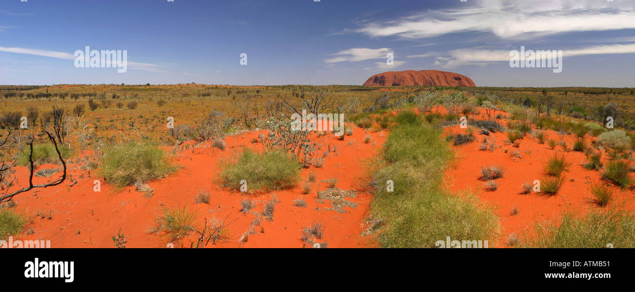 Evocative image of Ayers rock Uluru with bright vivid red sand northern ...