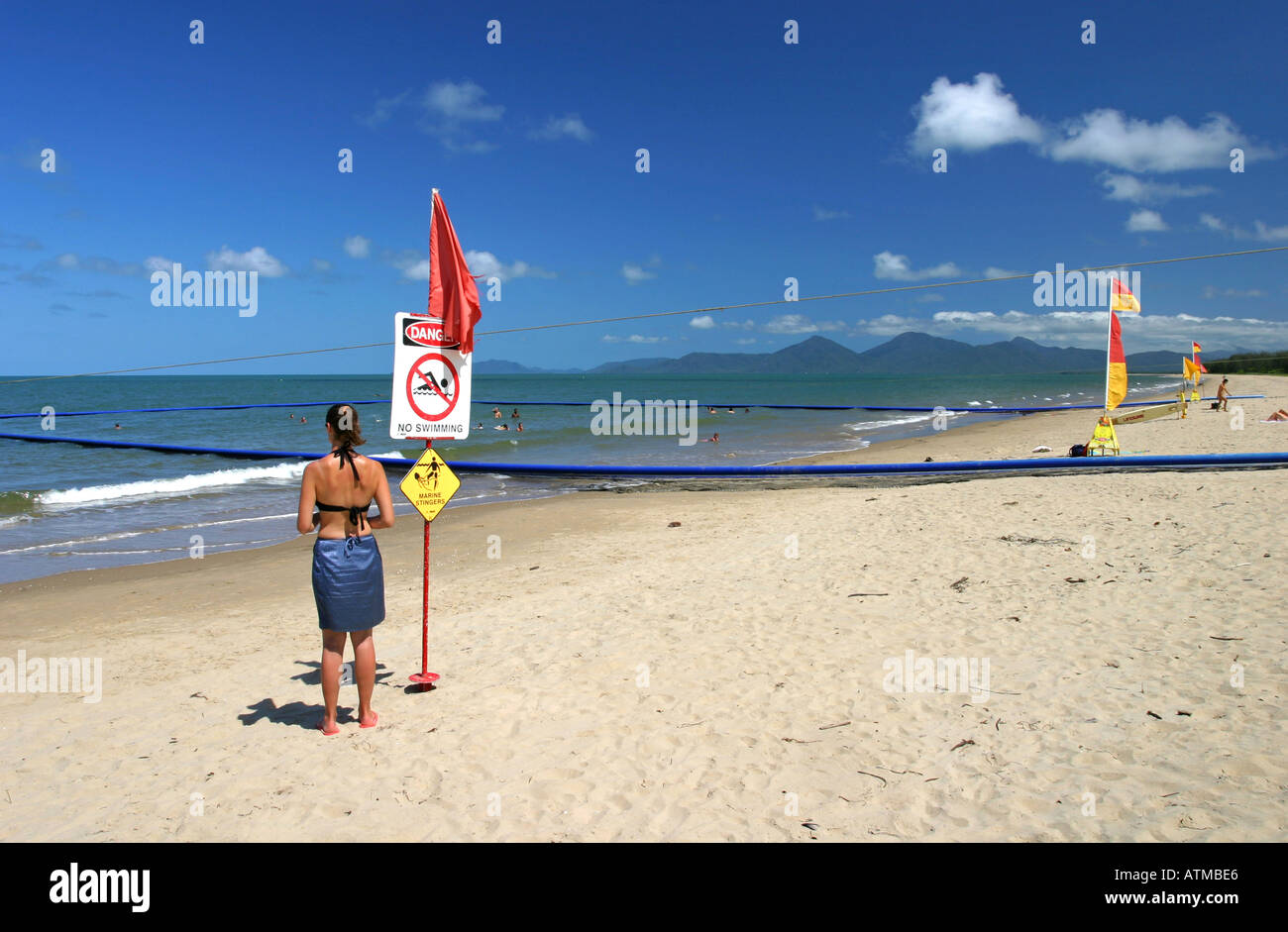 Young female tourist looks out to see on the Yorkeys Knob beach ...