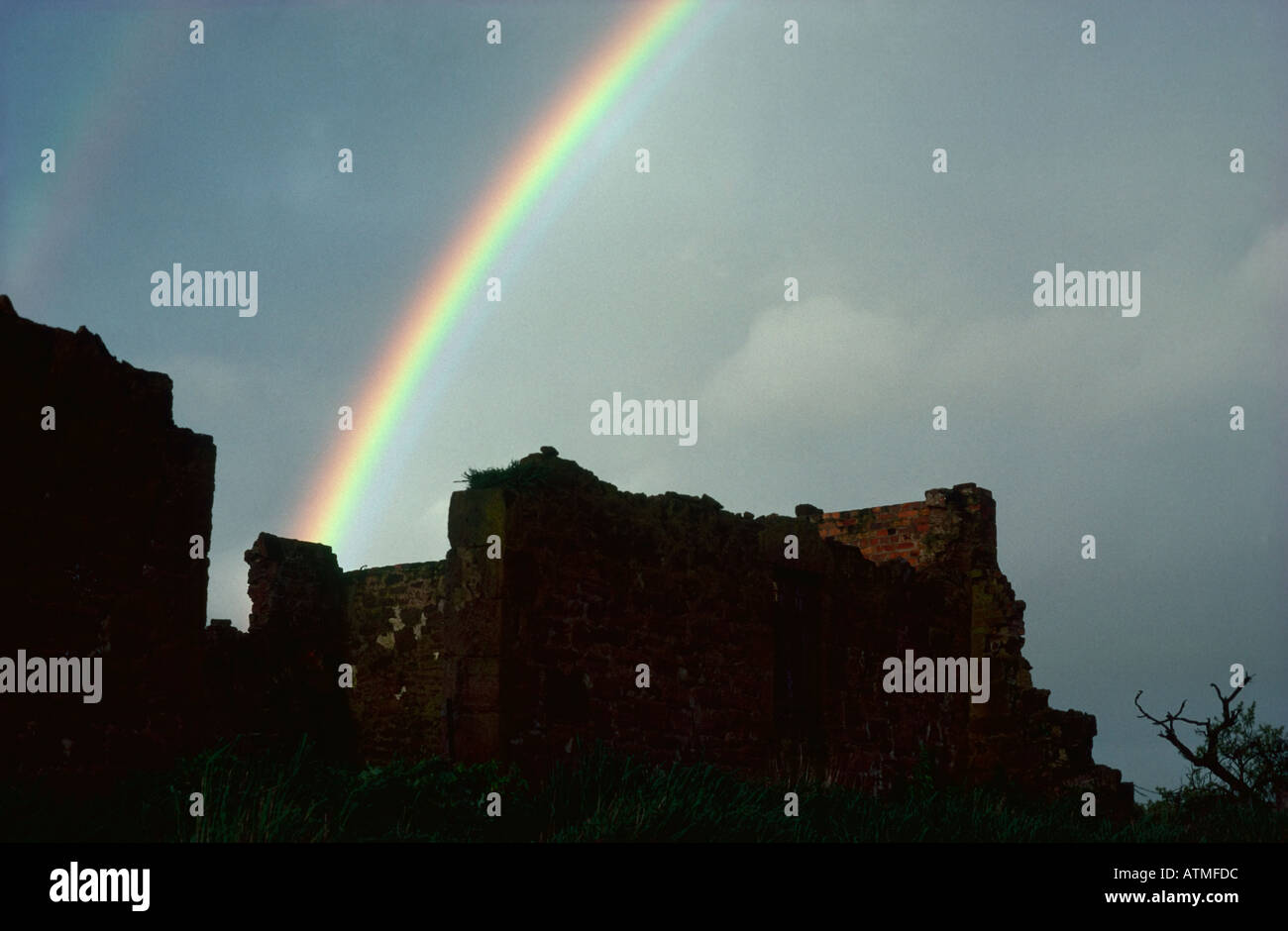 Rainbow over ruined stone wall building Stock Photo - Alamy