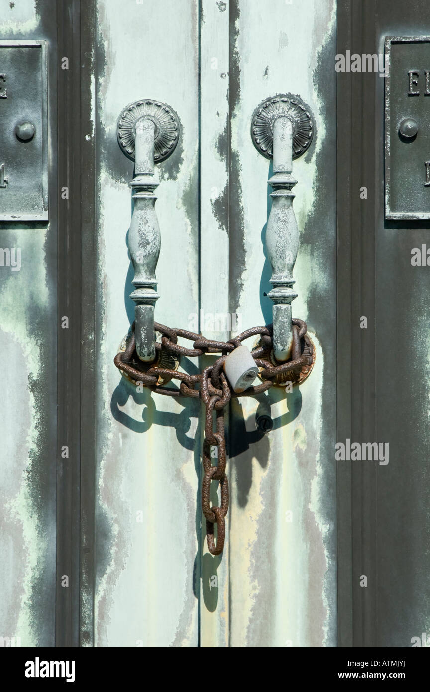 Doors locked and chained in worn and weathered old copper and bronze ...