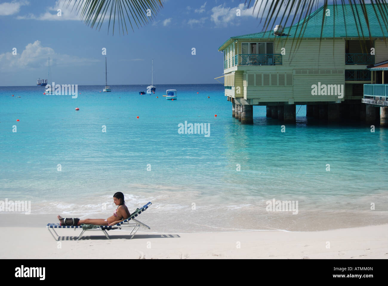 Person on sun lounger at Pebbles Beach, Barbados Caribbean Stock Photo ...