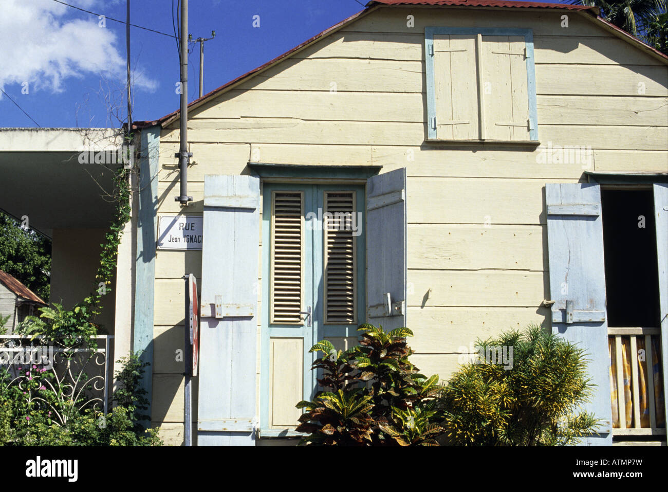 Pastel yellow clapboard house with blue shutters Part of French sign ...