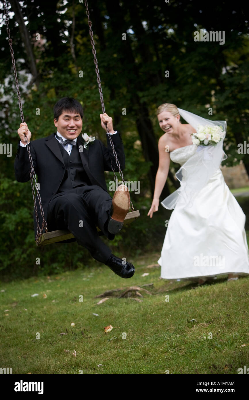 fun wedding with the groom being pushed on a swing by his laughing ...