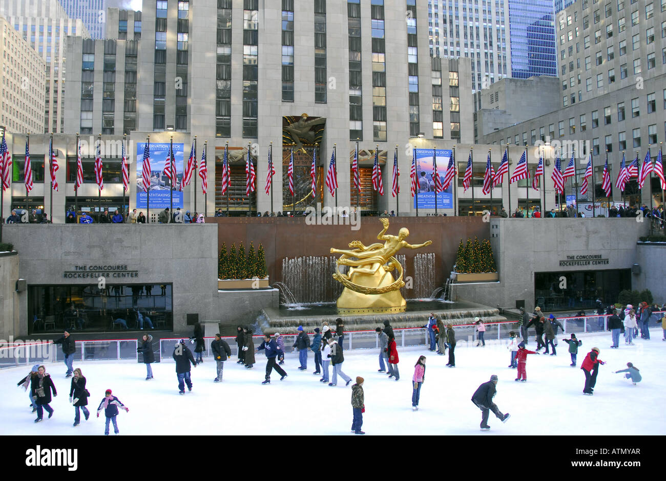 Ice skating on rink surrounded by city buildings in front of ...