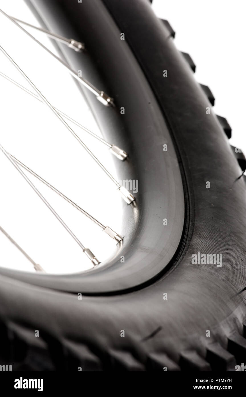 Angled closeup of a mountain bike wheel with silver spokes and a black ...