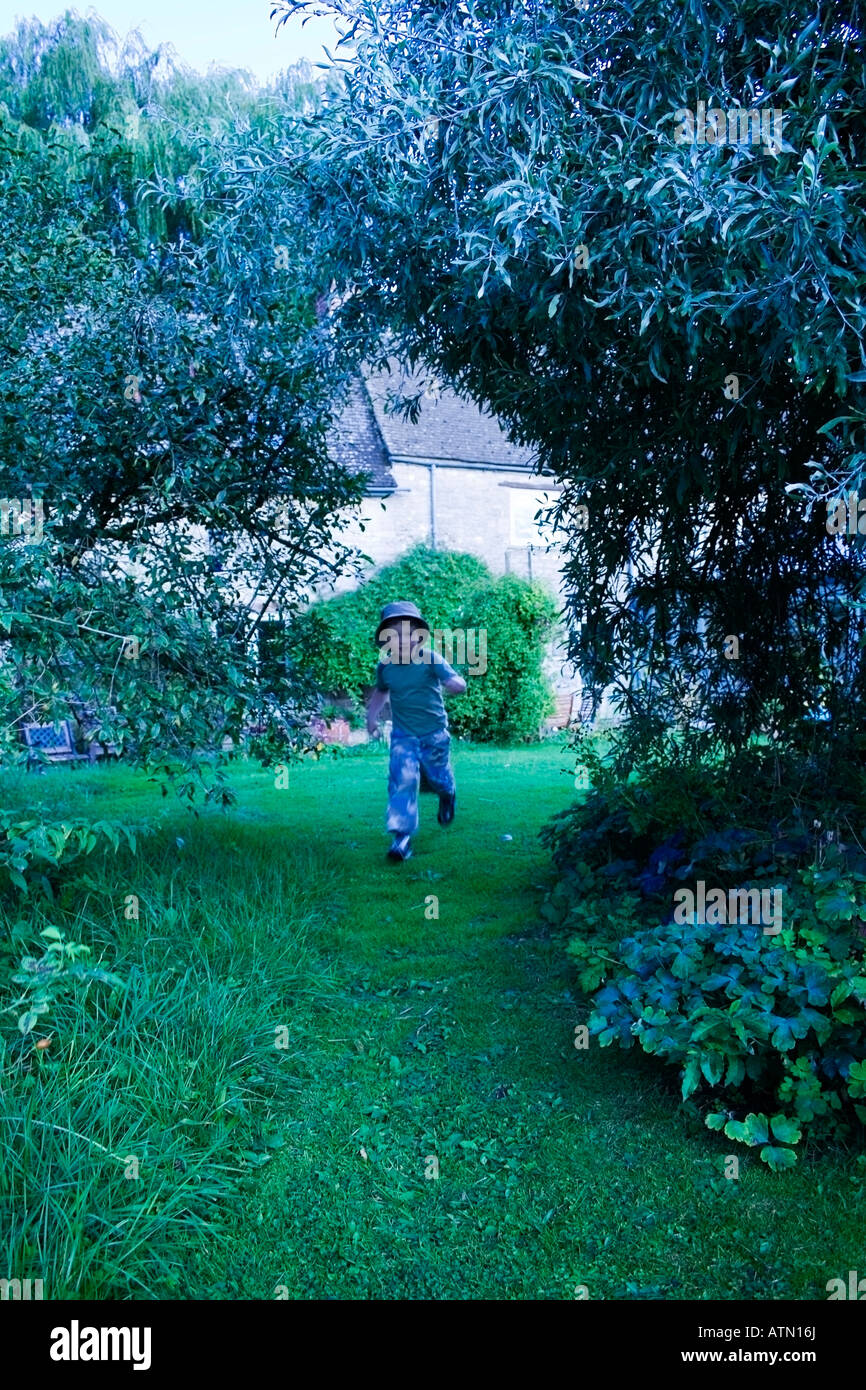 boy running through garden colour pushed green hue Stock Photo - Alamy
