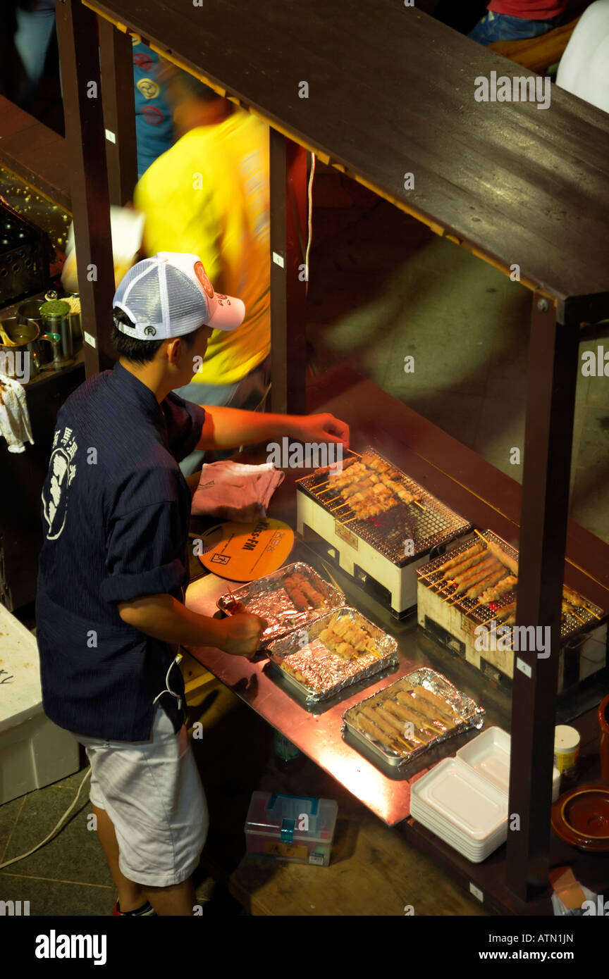 Kobe Japan Japanese man cooking chicken on a skewer Stock Photo - Alamy