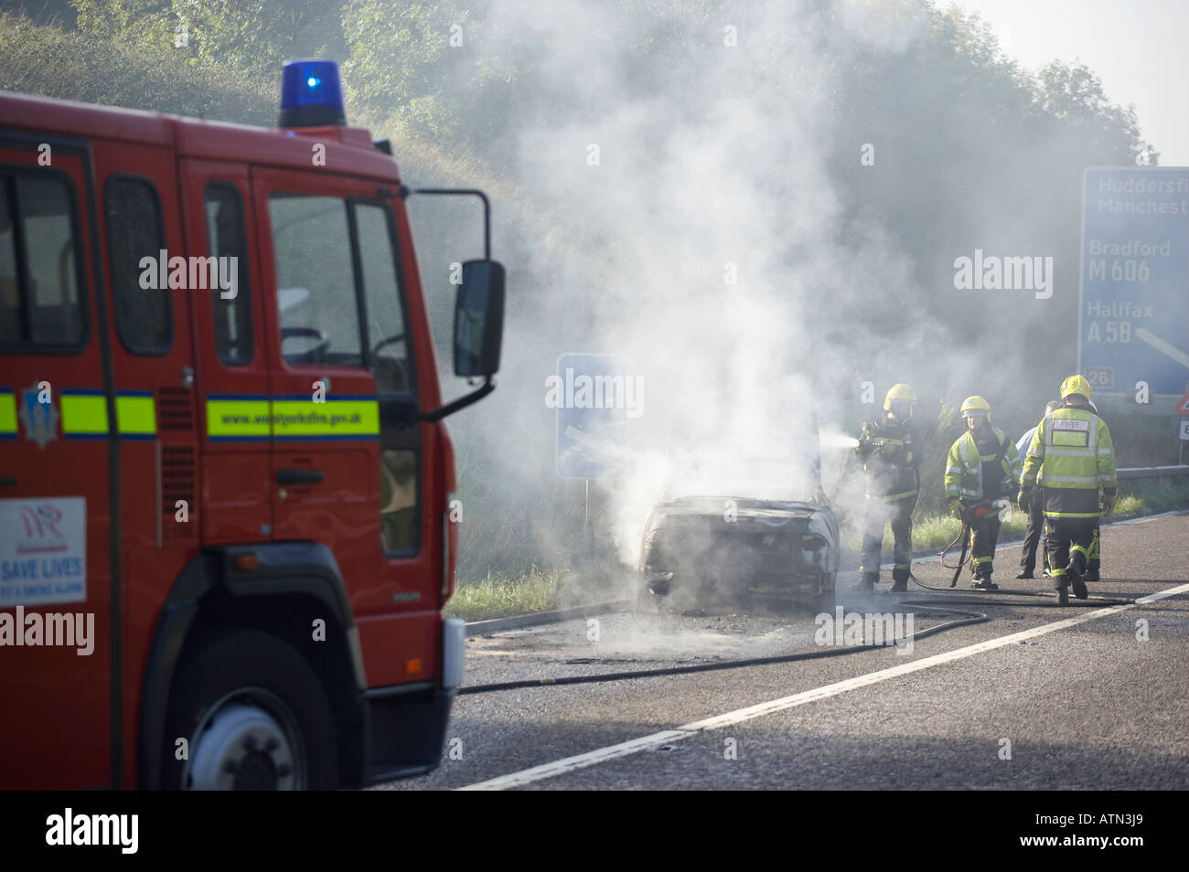 FIRE SERVICE ATTENDING BURNING CAR ON HARD SHOULDER OF M62 MOTORWAY ...