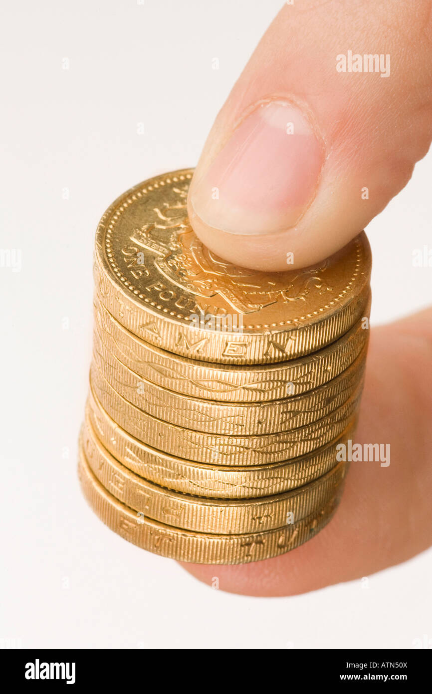 fingers holding pound coins Stock Photo - Alamy