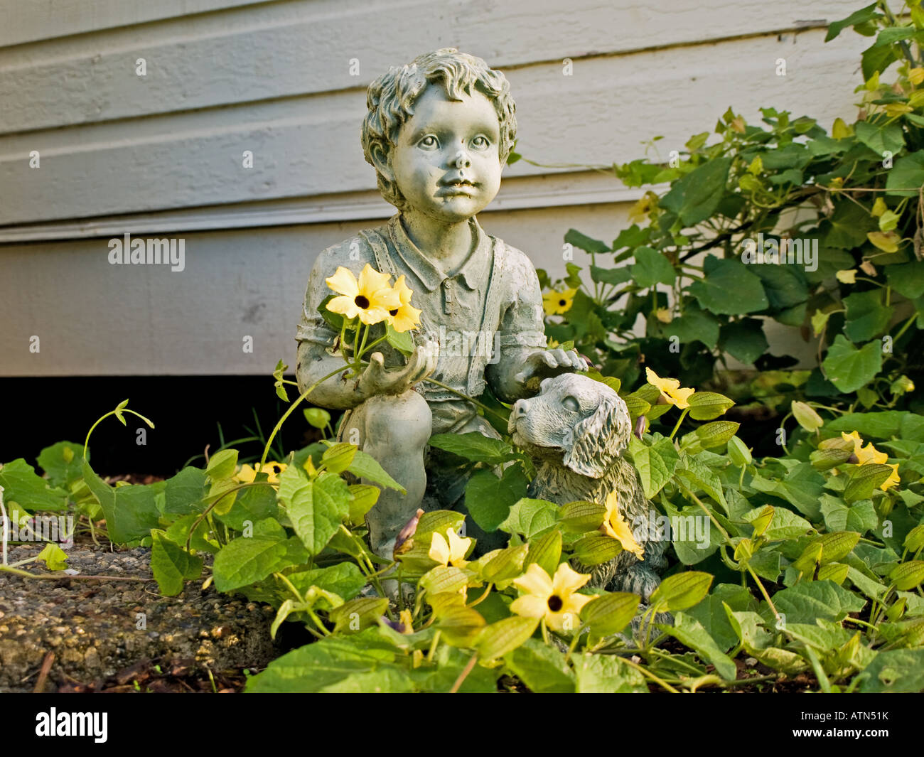 A garden statue with flowers growing on it Stock Photo - Alamy