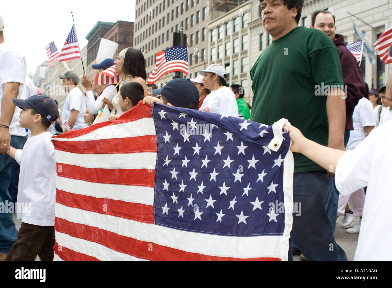 Hispanic activists holding large american flag in an immigration march ...