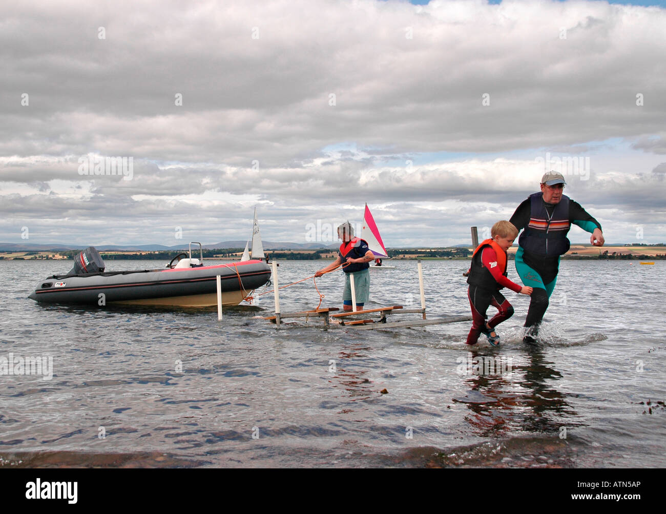 A father and son help to pull in the inflatable rescue raft, used ...