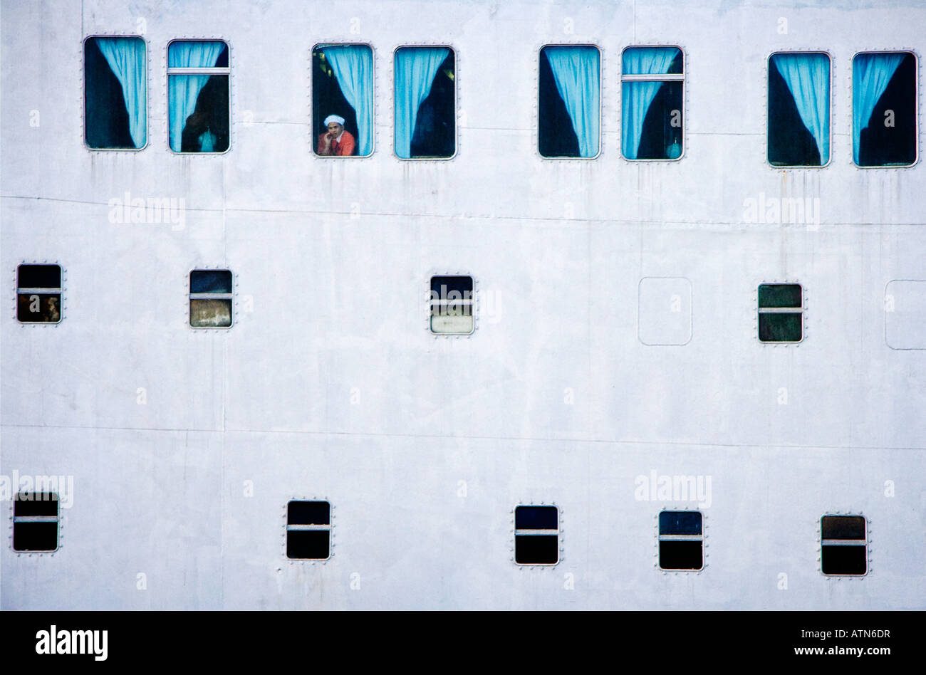 A passenger peers through the windows of a passenger ship Stock Photo ...