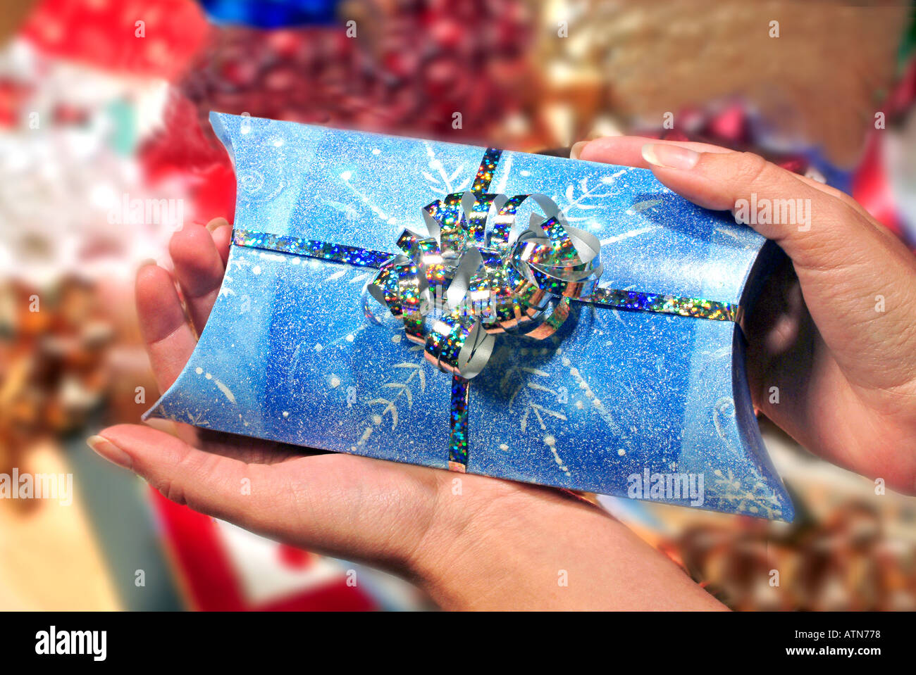 Female hand holding wrapped present Stock Photo - Alamy