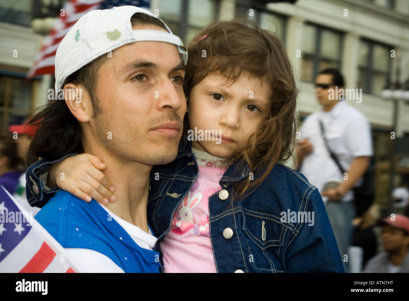 man holding his sad looking child at the demonstration rally for ...