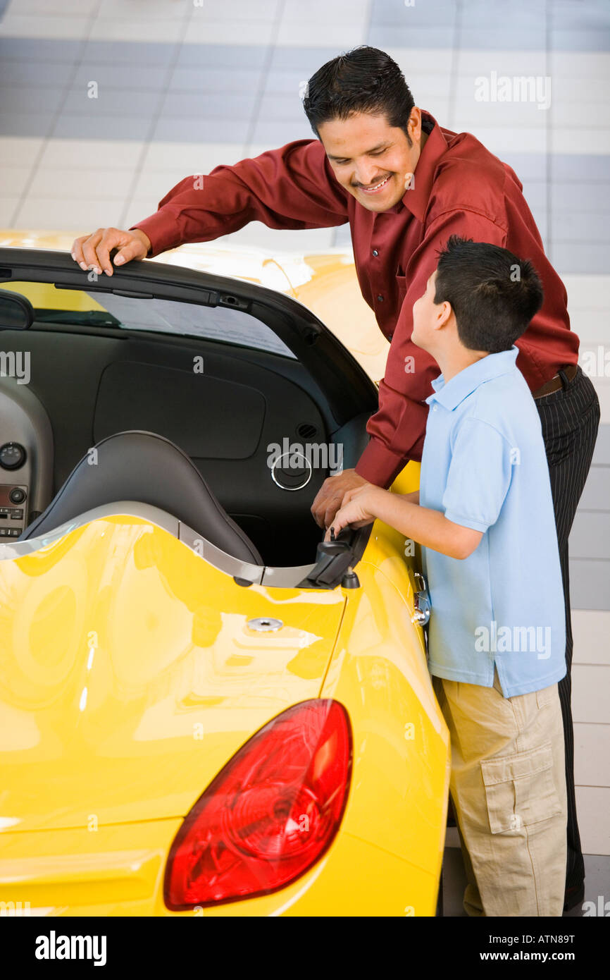 Hispanic father and son looking at new car Stock Photo - Alamy