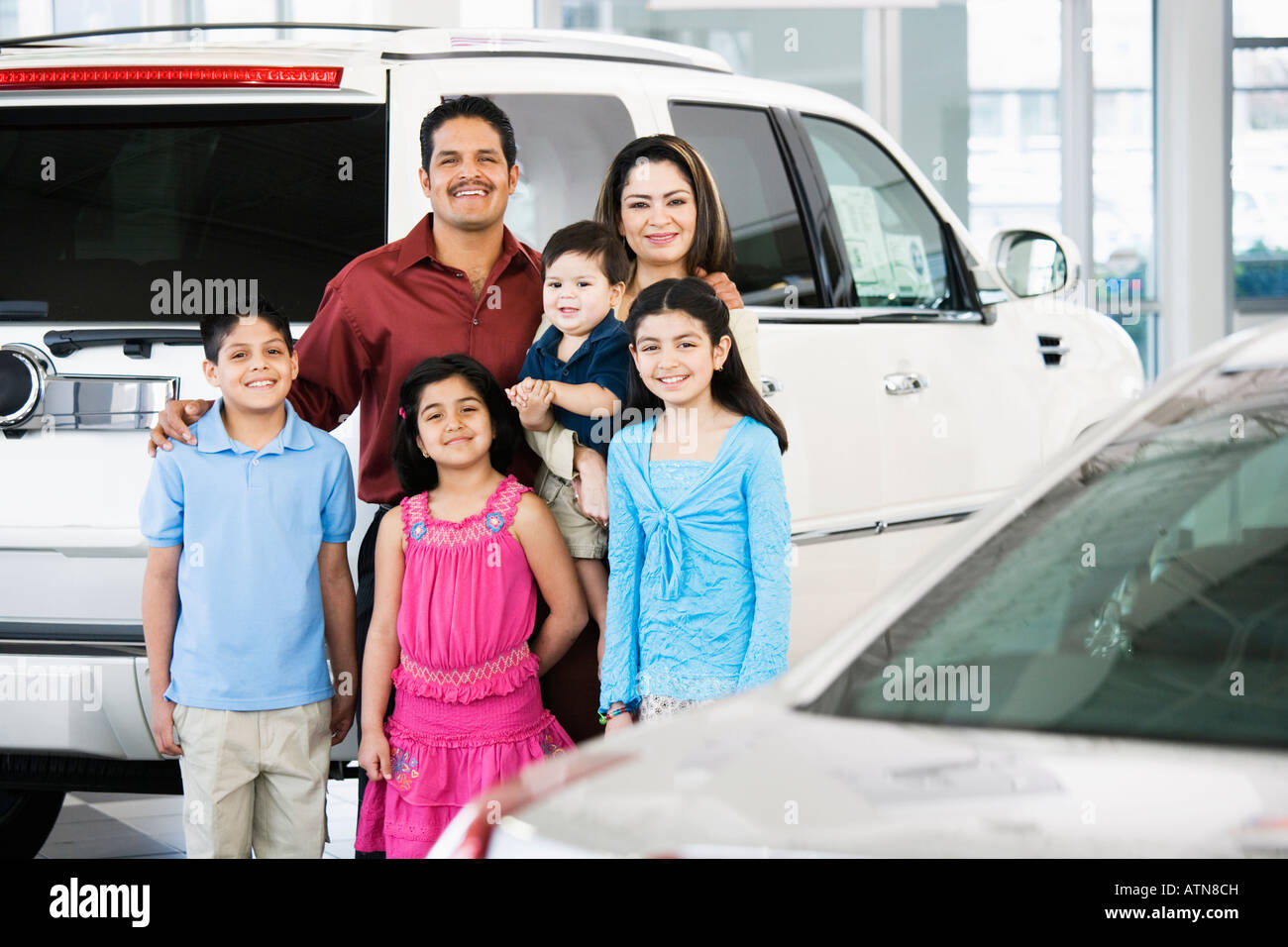 Hispanic family at car dealership Stock Photo - Alamy
