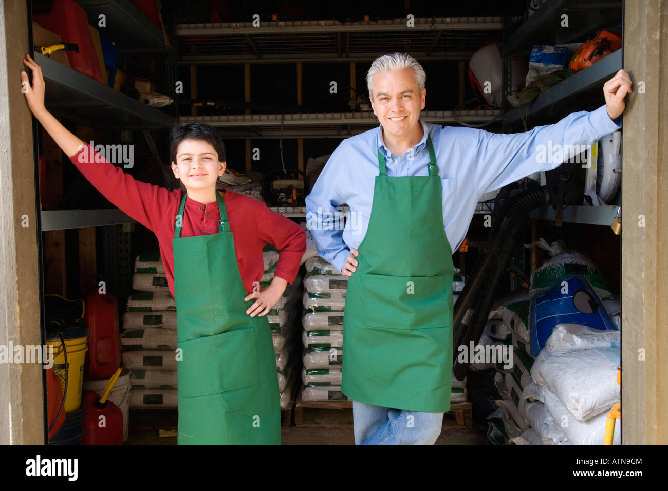 Hispanic father and son working at garden center Stock Photo - Alamy