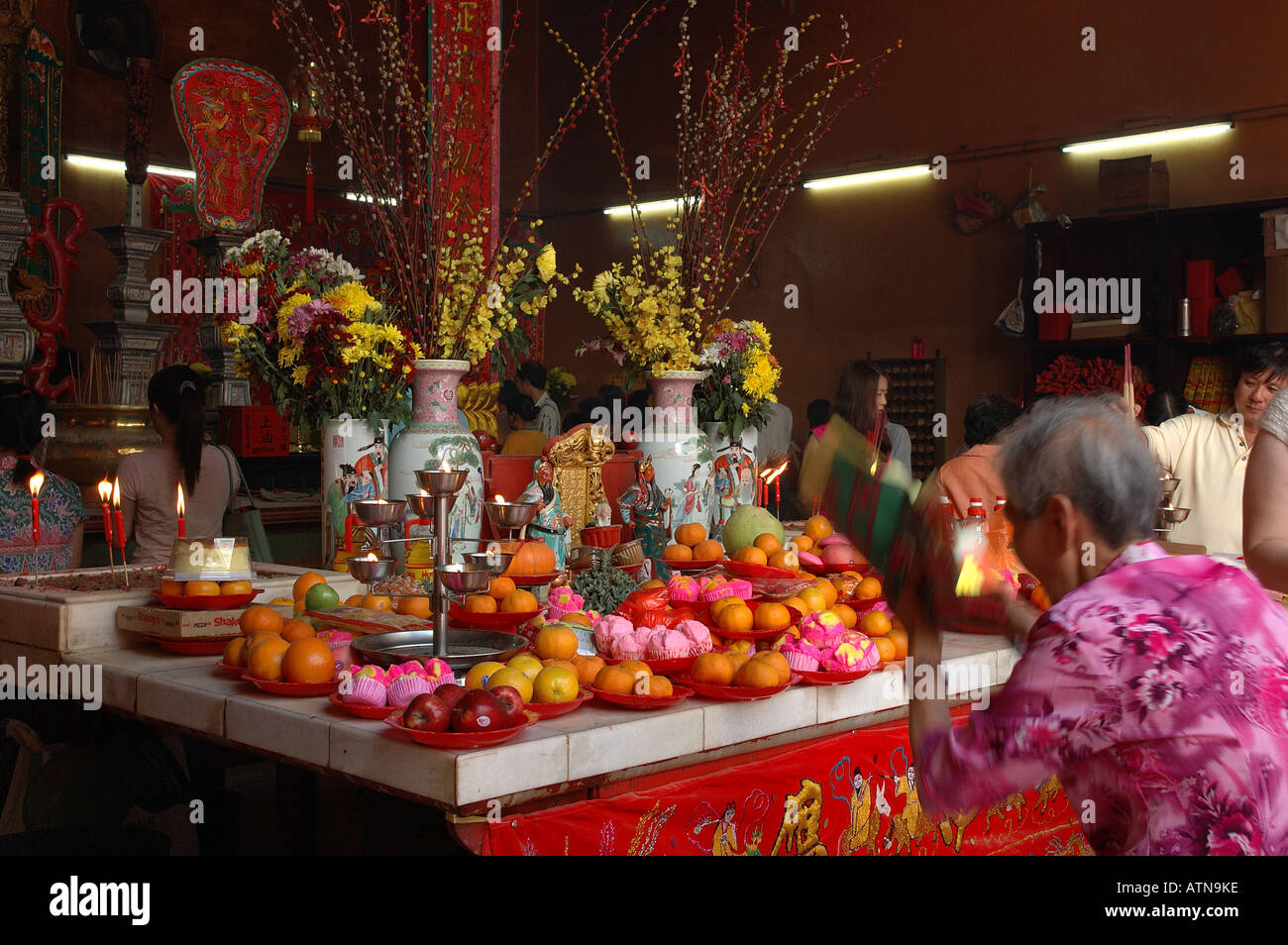Chinese woman praying at altar Stock Photo - Alamy