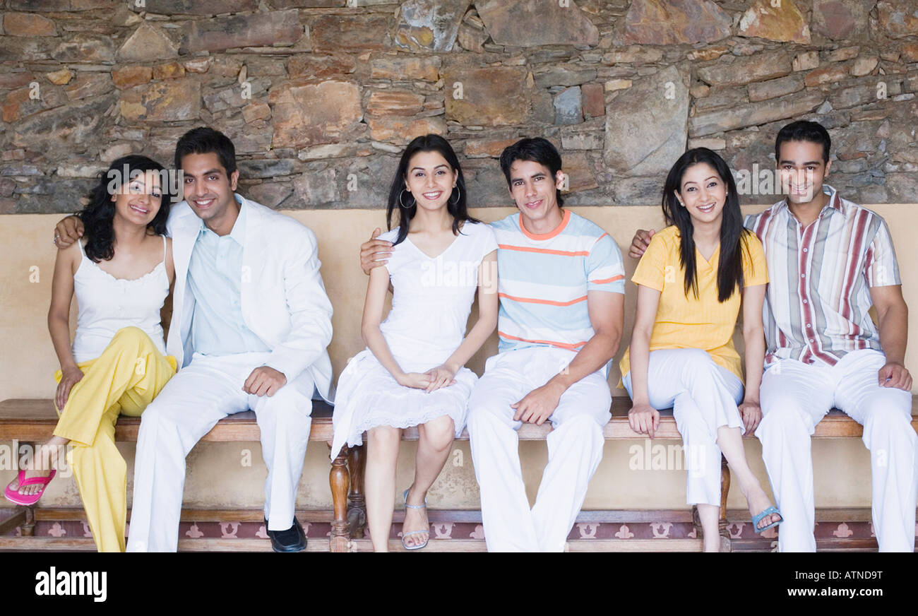 Portrait of three young couples sitting on a bench and smiling Stock ...