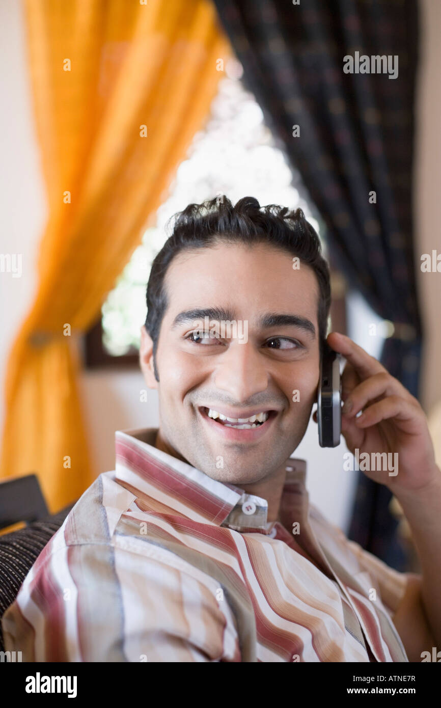 Side profile of a young man talking on a mobile phone and smiling Stock ...
