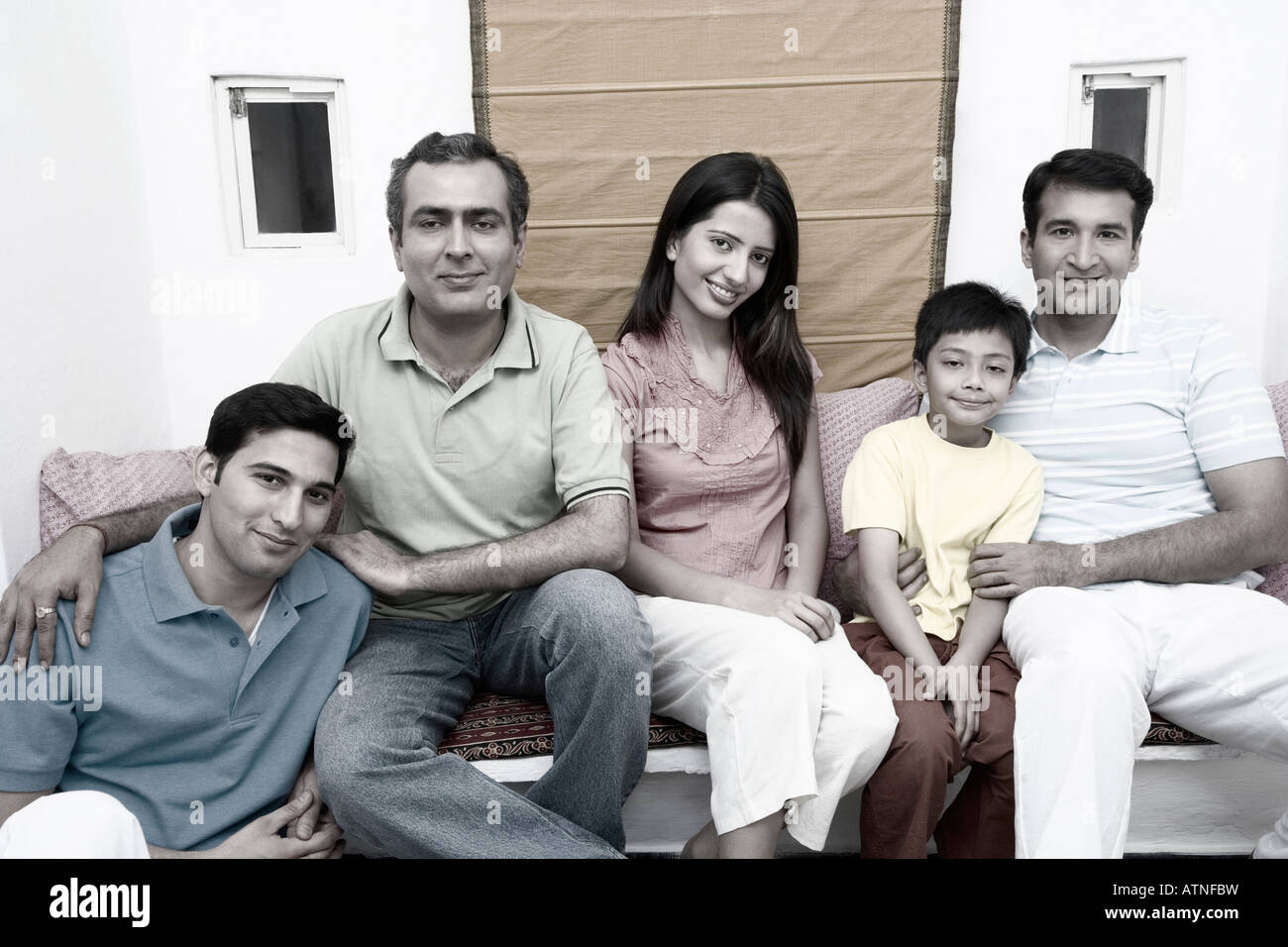 Portrait of five people sitting together on a couch and smiling Stock ...
