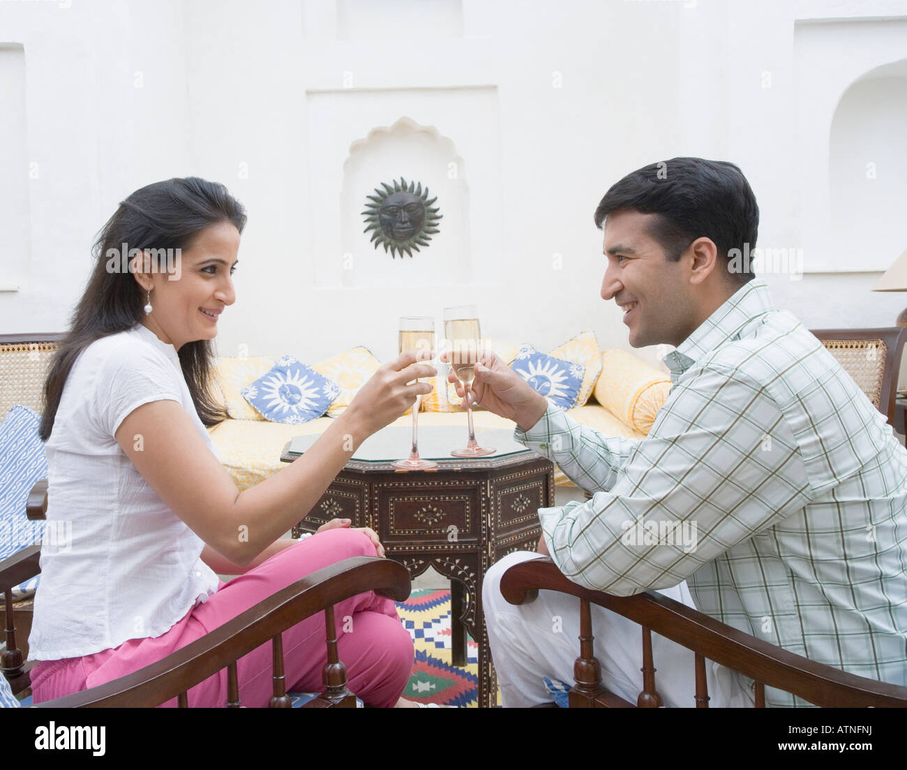 Side profile of a mid adult couple toasting with champagne flutes and ...