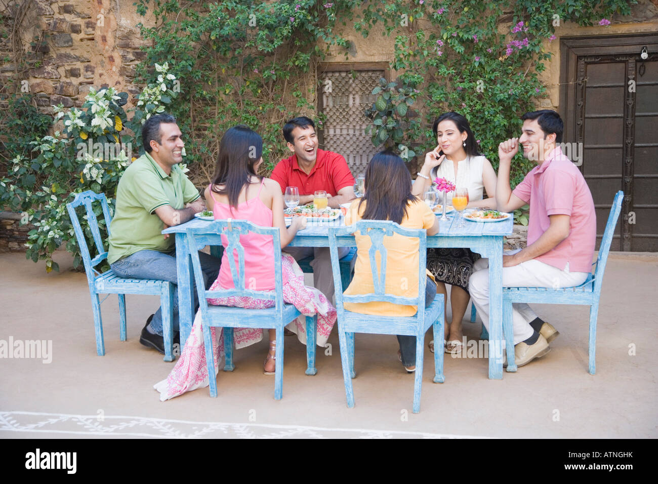Group of people sitting at a dining table Stock Photo - Alamy