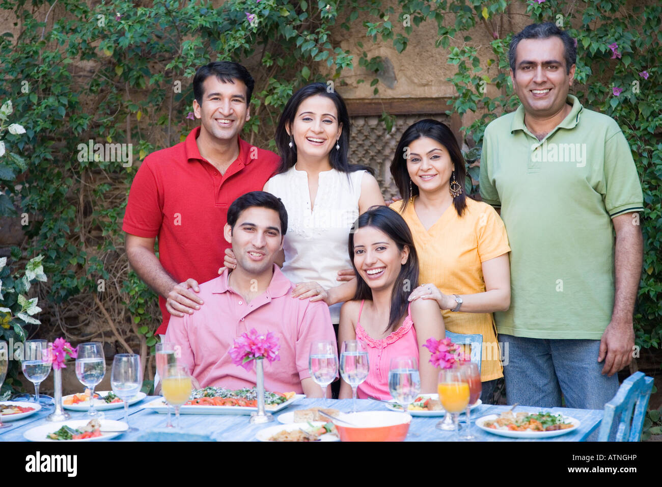 Portrait of a group of people at a dining table and smiling Stock Photo ...