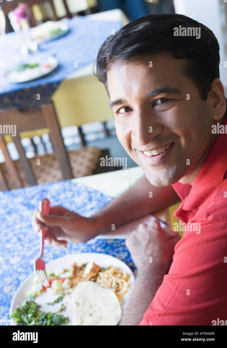 Portrait of a mid adult man eating food in a restaurant Stock Photo - Alamy