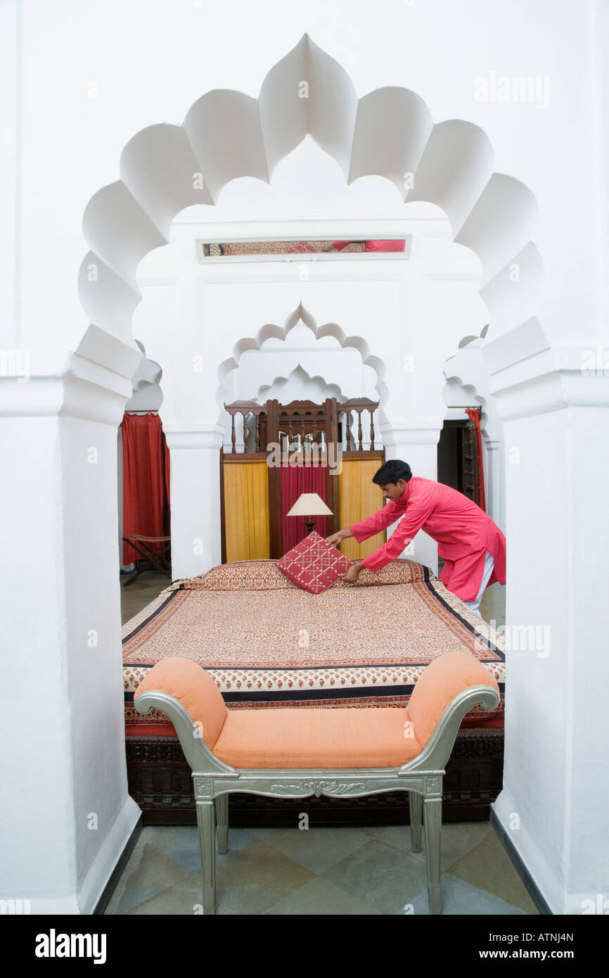 Side profile of a young man making a bed Stock Photo - Alamy
