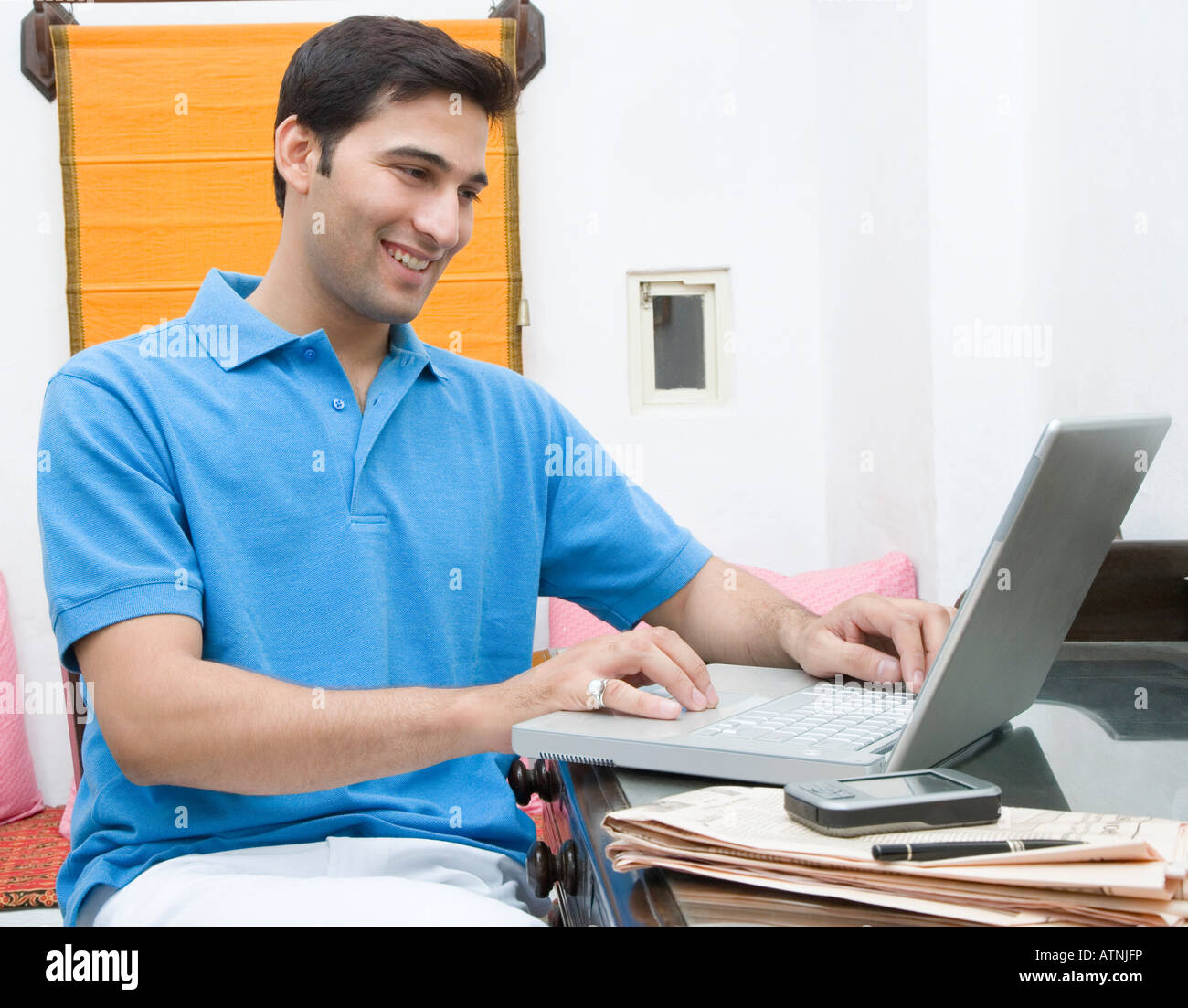 Close-up of a young man using a laptop and smiling Stock Photo - Alamy