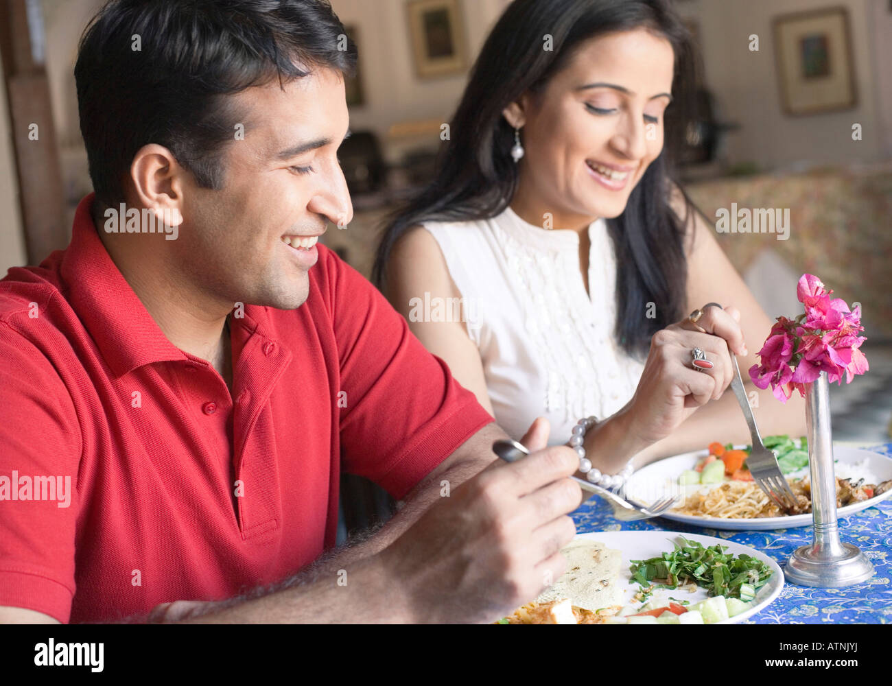 Mid adult couple having food in a restaurant and smiling Stock Photo ...