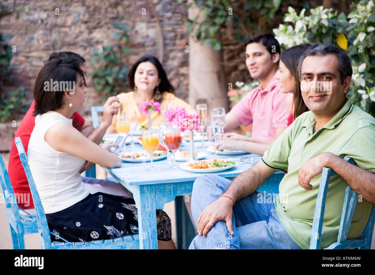 Group of people sitting at a dining table Stock Photo - Alamy