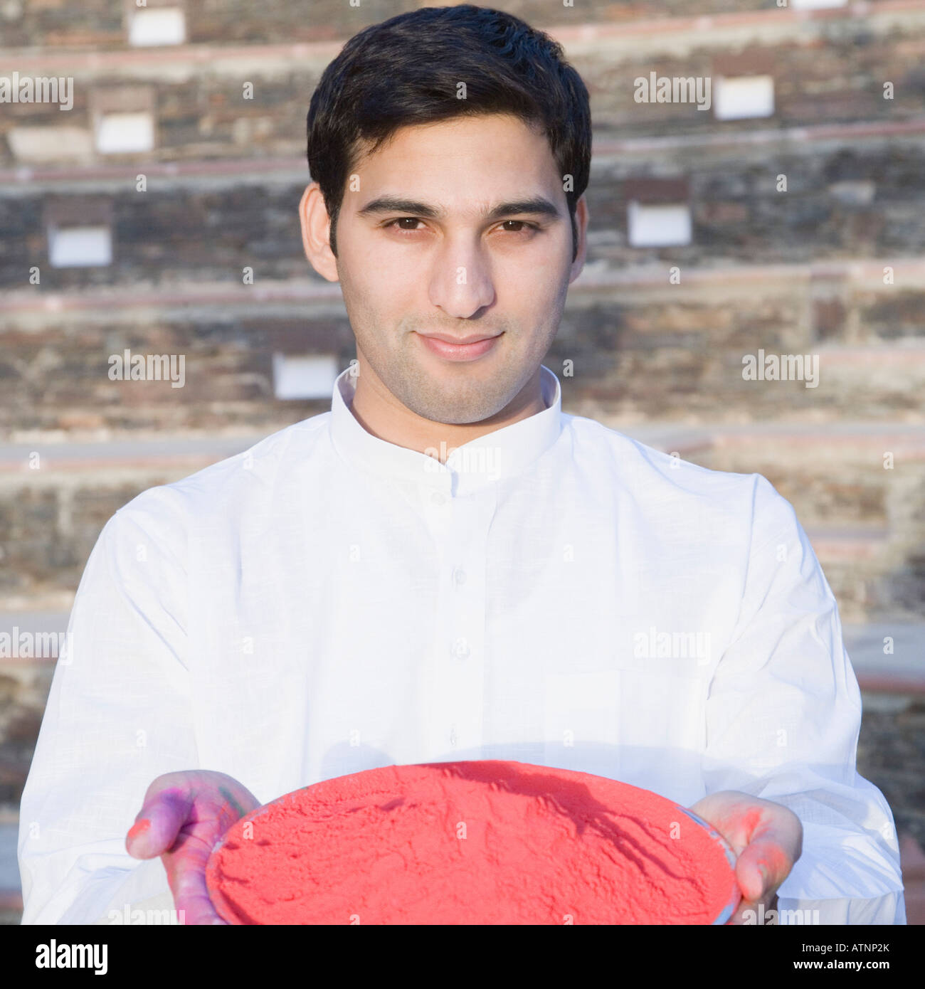 Portrait of a young man holding a plate of powder paint Stock Photo - Alamy