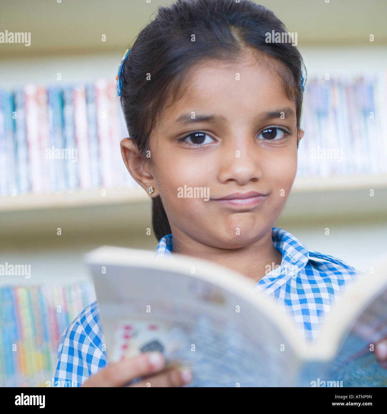 Portrait of a girl holding a book and making a face Stock Photo - Alamy