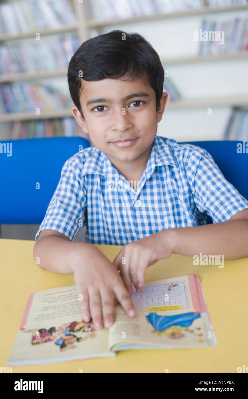 Portrait of a boy reading a book in a school library Stock Photo - Alamy